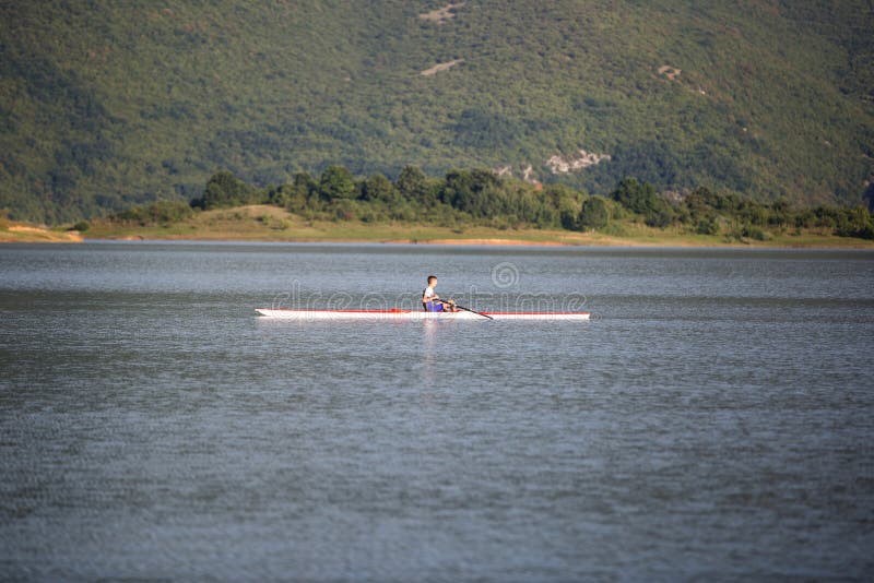 A Young Single Scull Rowing Competitor Paddles on the Tranquil Lake ...