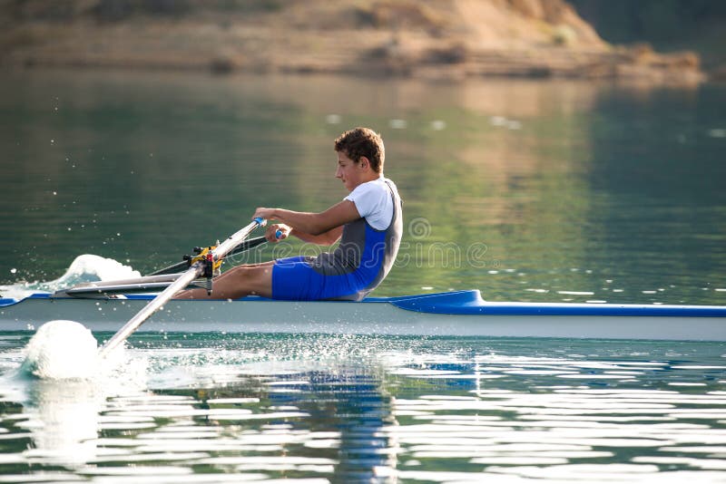 A Young Single Scull Rowing Competitor Paddles on the Tranquil Lake ...