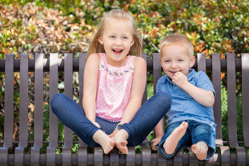 Young Sister and Brother Having Fun on the Bench at the Park Stock ...