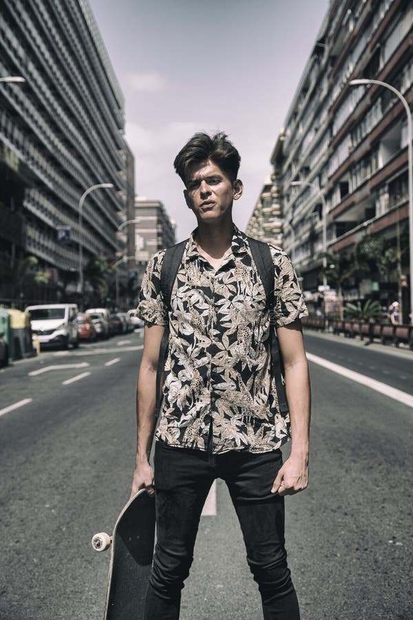 Young Skateboarder Man with Bad Boy Face in the Middle of the Street ...