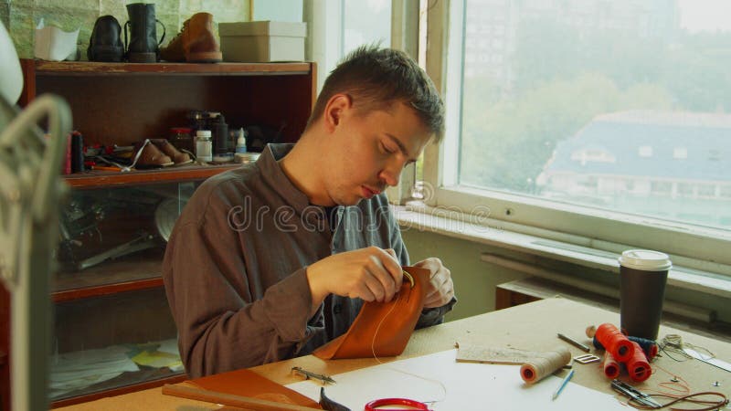 A Young Skilled Tailor Sews the Element To a Leather Bag Using a Tailor ...