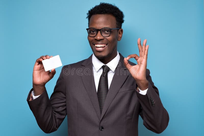 Young Smiling African Man Holding Credit Card And Showing Okay Sign ... Young Smiling African Man Holding Credit Card And Showing Okay Sign ...