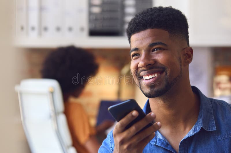 Young Smiling Businessman Working at Desk in Office Talking into Mic of ...