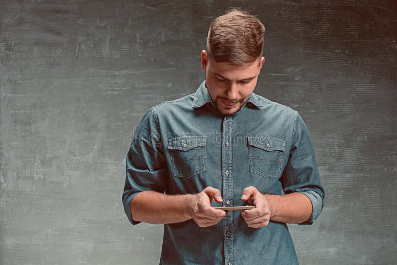 The Young Smiling Caucasian Businessman on Gray Background with Phone ...
