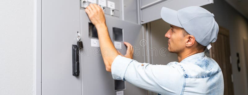 Young Smiling Electrician Doing His Work, Electrical Panel Stock Photo ...