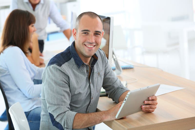 Young Smiling Man at Office Using Tablet Stock Image - Image of ...