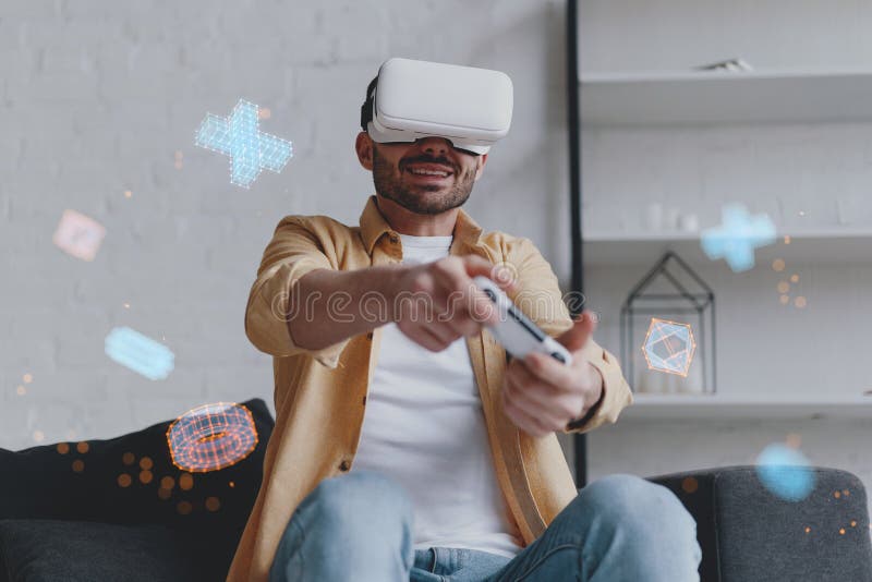 Young Smiling Man in VR Glasses Playing Game Using Joystick, Augmented ...