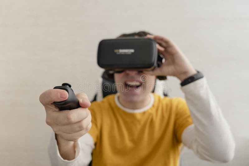 Young Smiling Man in VR Glasses Playing Video Game with Joystick ...