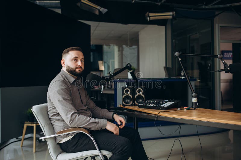 Young Smiling Radio Host Talking into a Microphone and Broadcasting in ...