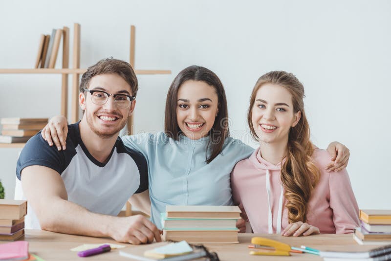 Young Smiling Students Sitting at Table with Books Stock Image - Image ...