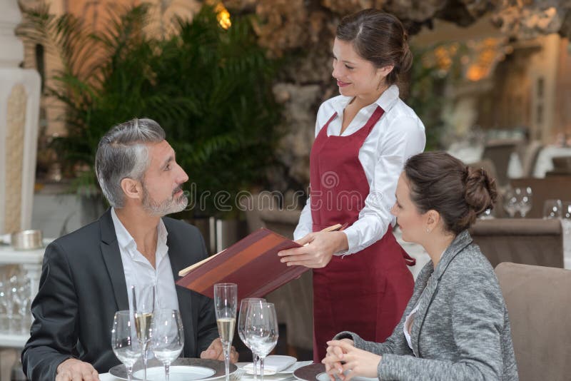 Young Smiling Waitress Serving Couple in Restaurant Stock Image - Image ...