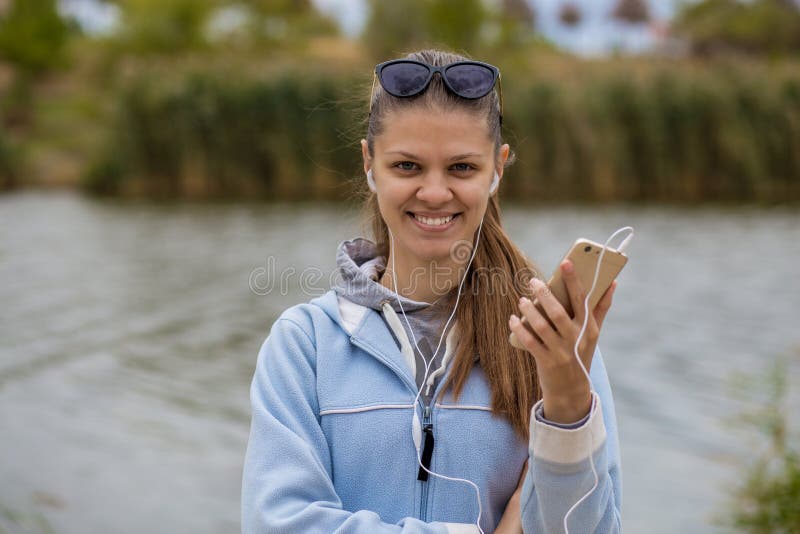 Young Smiling Woman With A Phone Listens To Music Stock Image Image