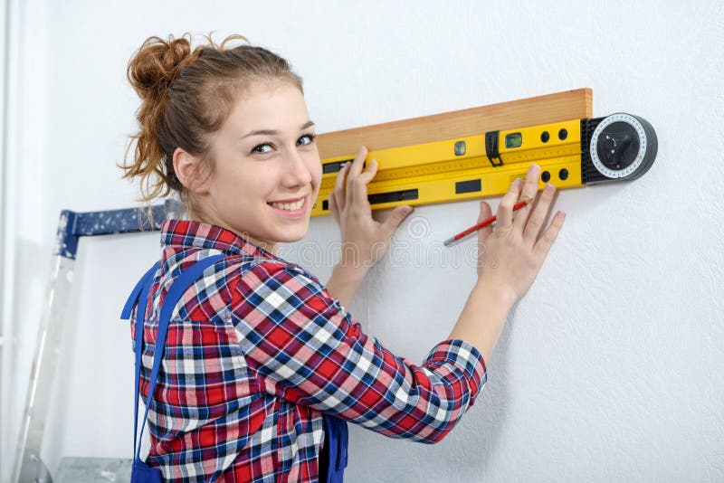 Young Smiling Woman Using Spirit Level Stock Photo - Image of building ...