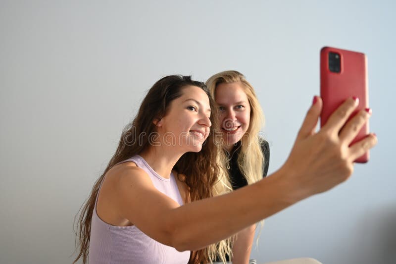 Young Smilling Women Making Selfie On The Light Room Portrait Of Two