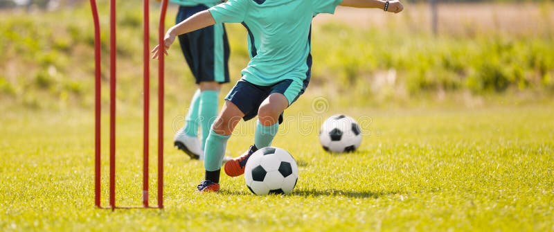 Young Soccer Player Practicing Dribbling Skills through Training Poles ...