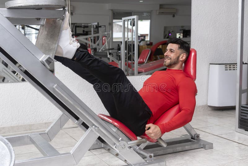 Young Sportsman Training Leg Muscles in Gym. Stock Image - Image of ...