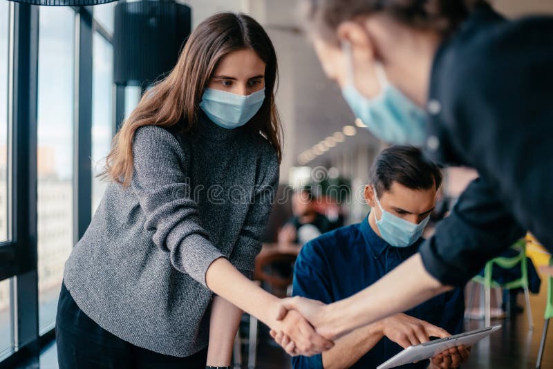 Young Staff in Protective Masks Shaking Hands with Each Other. Stock ...