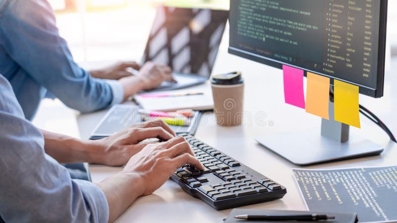 Young Startup Programmers Sitting at Desks Working on Computers Screen ...