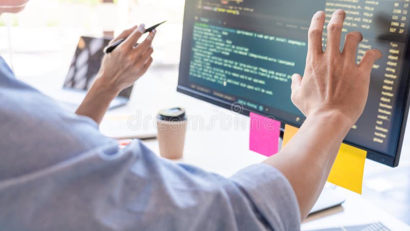 Young Startup Programmers Sitting at Desks Working on Computers Screen ...