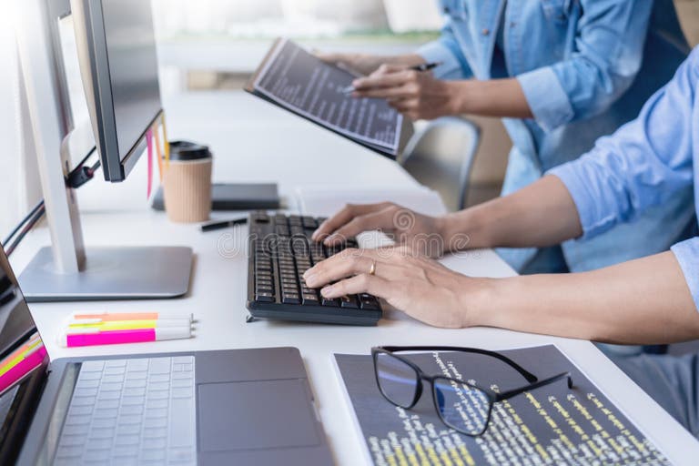 Young Startup Programmers Sitting at Desks Working on Computers Screen for Developing ...