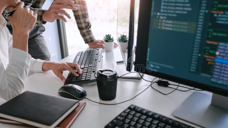 Young Startup Programmers Sitting at Desks Working on Computers Screen ...