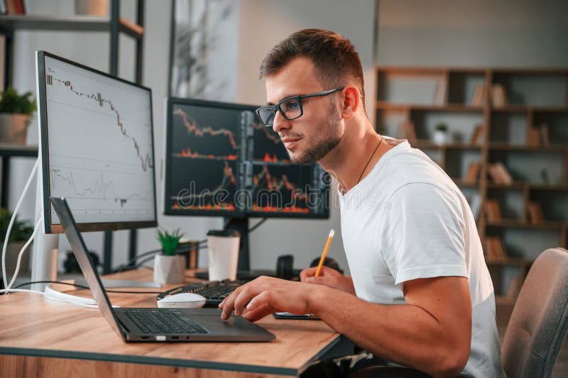 Young Stock Broker is Working in the Office by Using Computer Stock ...