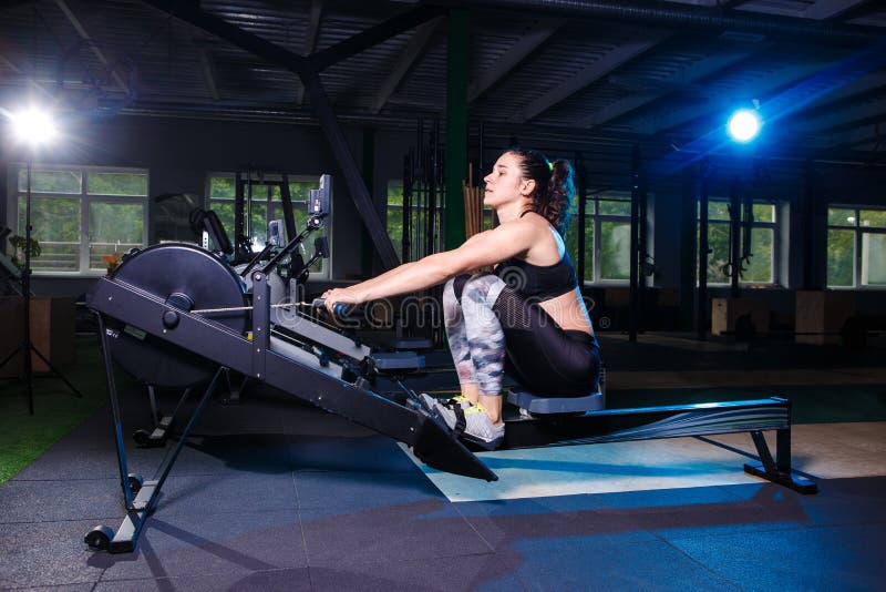 Young Strong Girl Doing an Exercise on a Rowing Machine. for Training ...