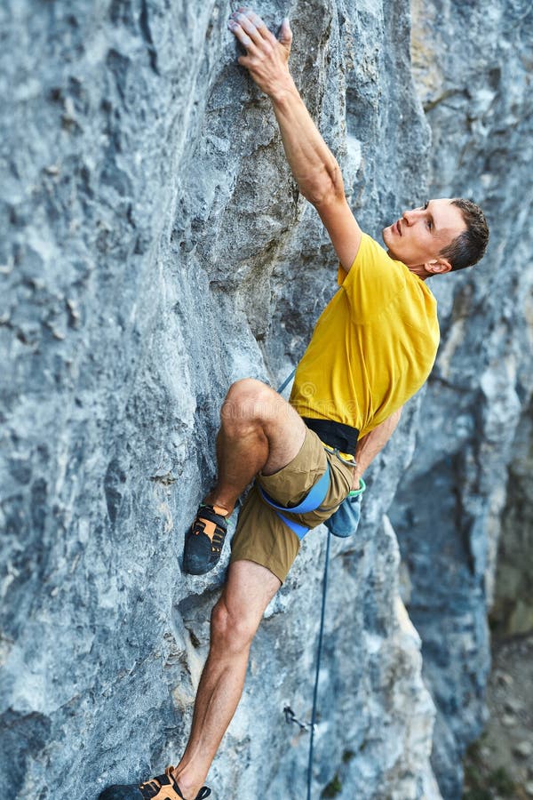 Young Strong Man Climbing Challenging Route on a High Vertical ...