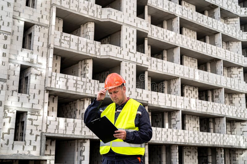 Young Strong Worker in Uniform with a Tablet in His Hands is at the ...