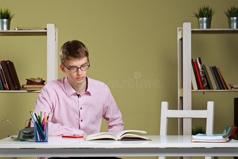 Young Student Behind the Desk Reading the Book. Stock Photo - Image of ...