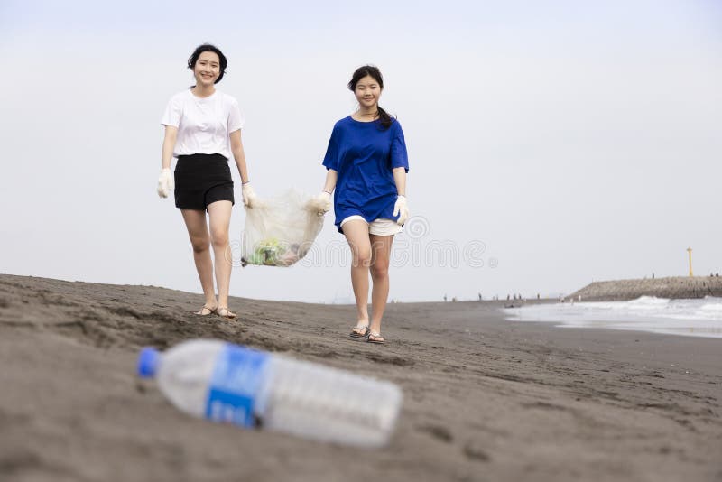 Young Student Collecting Plastic Waste on the Beach. People Cleaning ...
