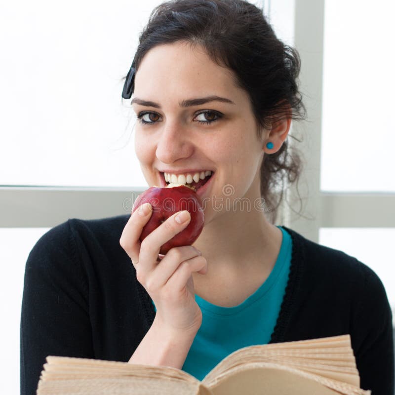 Young Student Eating an Apple while Reading a Book Stock Image - Image ...