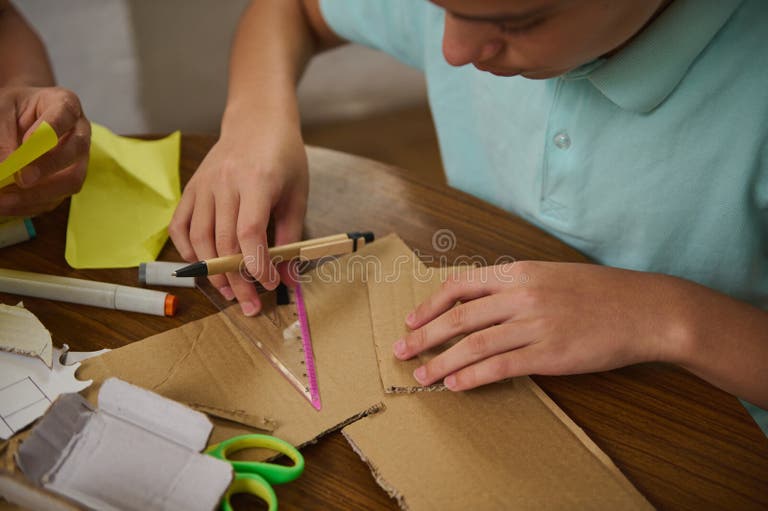 Young Student Engaging in Crafts with Recycled Cardboard and Measuring ...