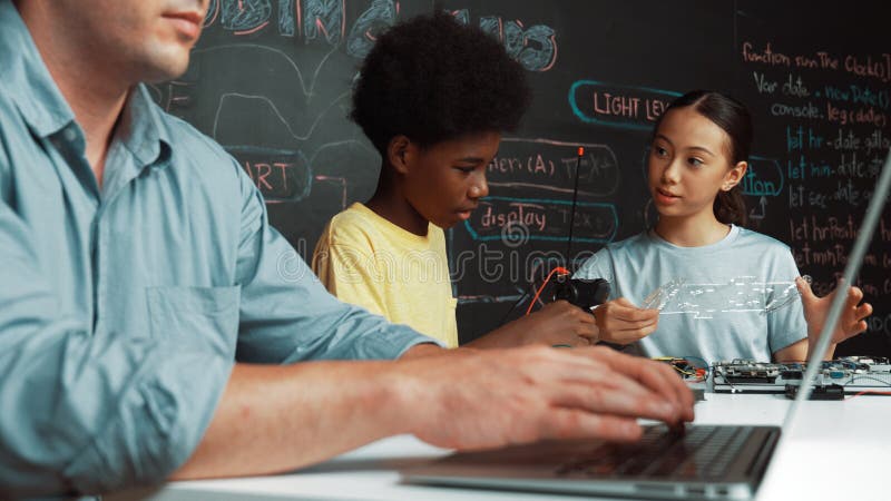 Young Student Fixing Controller while Teacher Programing Code ...