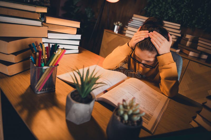 Young Student Studying at Home Surrounded by Books and Supplies in a ...