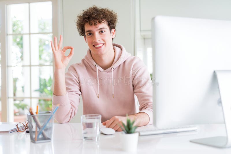 Young Student Man Using Computer Doing Ok Sign with Fingers, Excellent ...