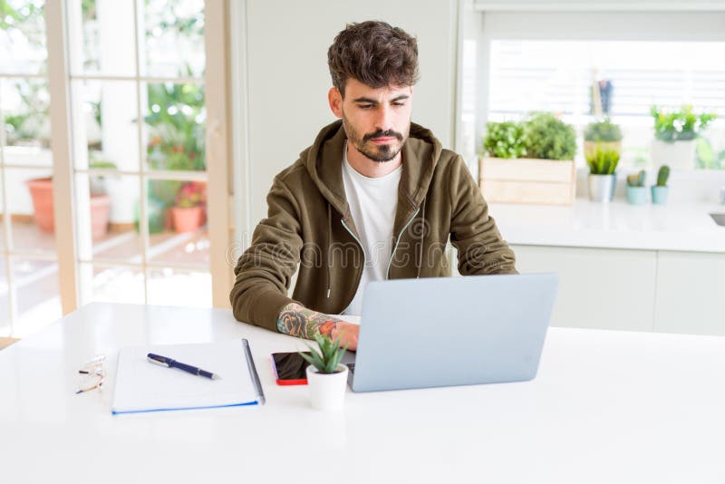Young Student Man Using Computer Laptop and Notebook with a Confident ...