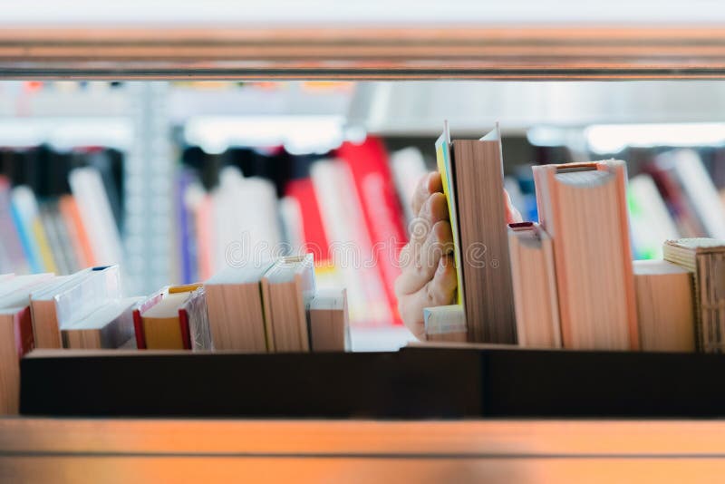 Young Student Picking a Book from the Shelf in the Library. Preparing ...