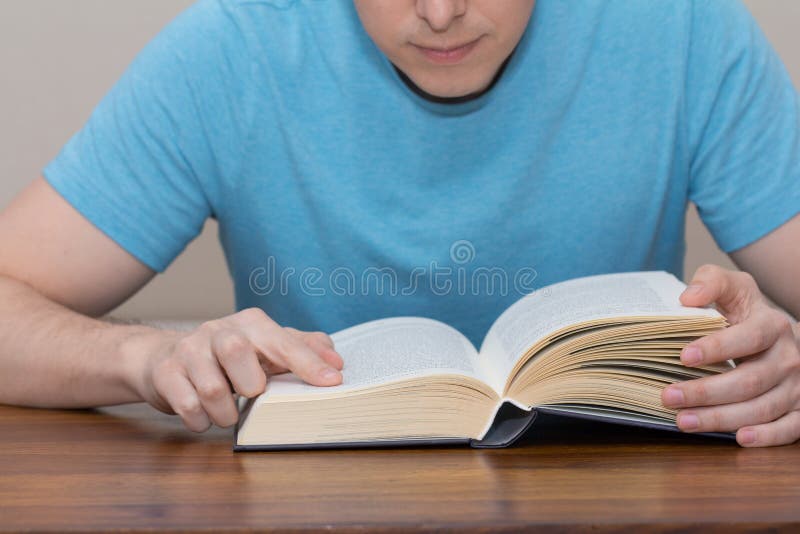 Young Student Reading Book on Desk Stock Photo - Image of hands ...