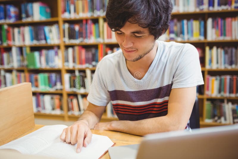 Young Student Sitting at Desk Reading a Book Stock Image - Image of ...