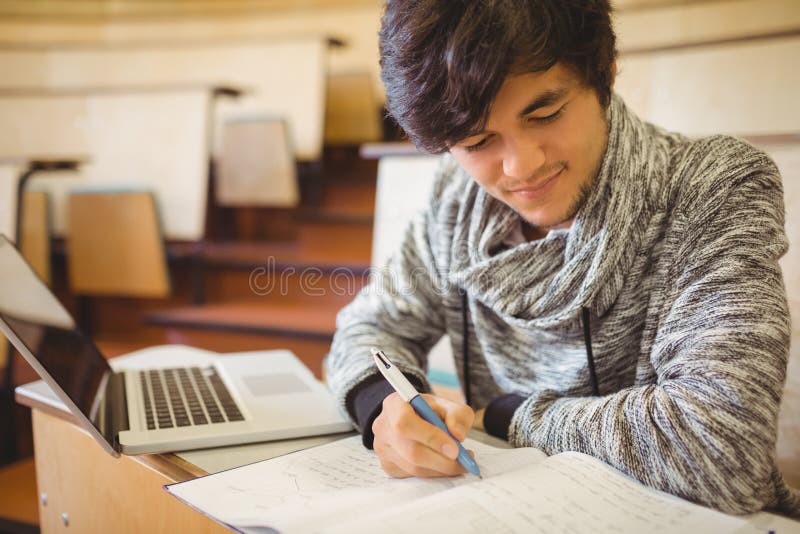 Young Student Sitting at a Desk Writing Notes Stock Photo - Image of ...
