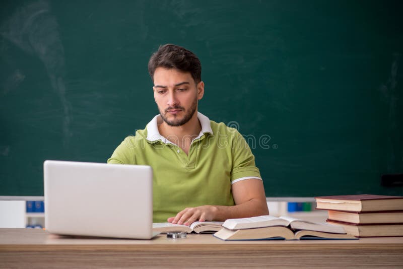 Young Male Student Sitting in Front of Green Board Stock Photo - Image ...