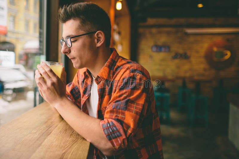 Young Student is Sitting in the Restaurant and Taste a Warm Drink. Man ...