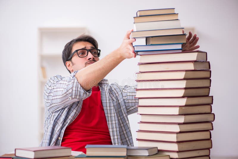 Young Male Student and Too Many Books in the Classroom Stock Photo ...