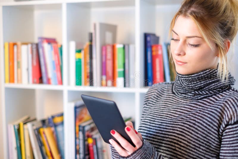 Young Student Using E-book and Bookshelf on Background Stock Image ...
