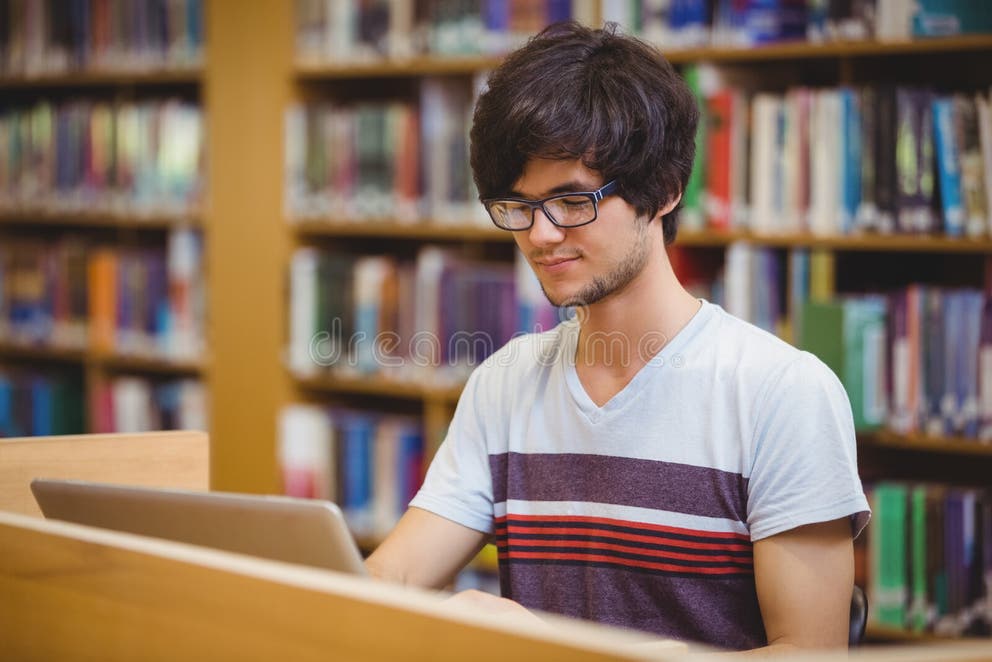 Young Student Using His Laptop in Library Stock Image - Image of casual ...
