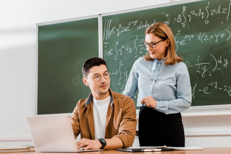Young Student Using Laptop and Sitting Near Teacher Stock Photo - Image ...