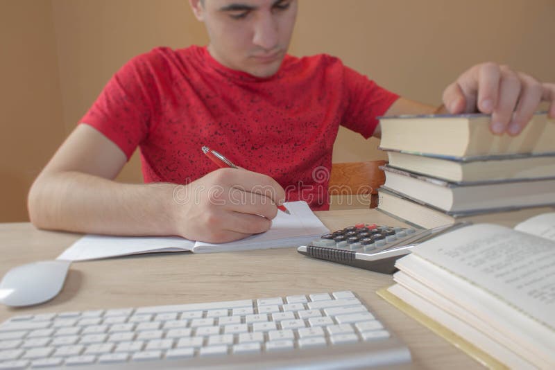 Young Student Write in Notebook between Books. Young Student Studying ...
