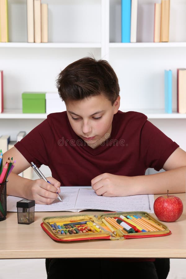 Young Student Writing in His Exercise Book at School Stock Image ...