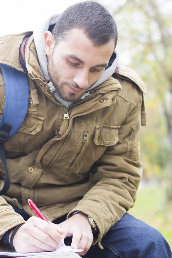 Young Student Writing in His Note Book Stock Image - Image of sitting ...